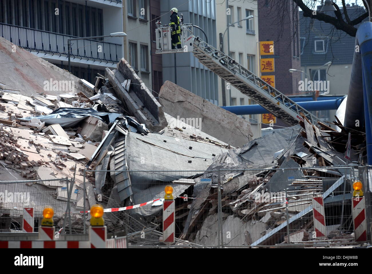 A firefighter hovers over Cologne?s collapsed Historic City Archive in ...