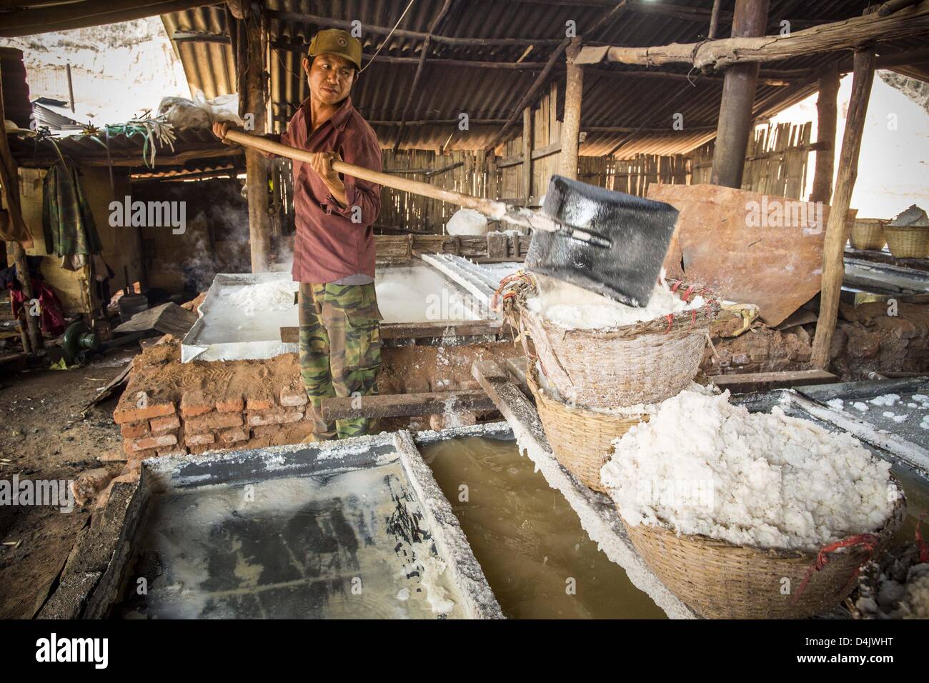 March 13, 2013 - Boten, Luang Namtha, Laos - A man shovels salt into a ...