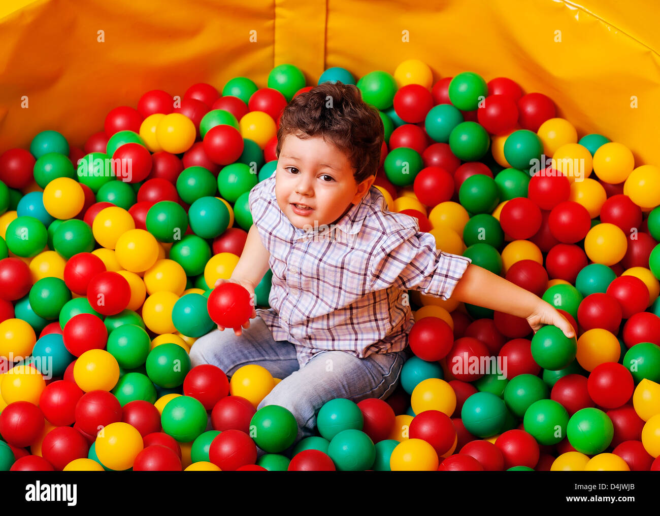 Cute kid or child playing colorful balls top view Stock Photo - Alamy