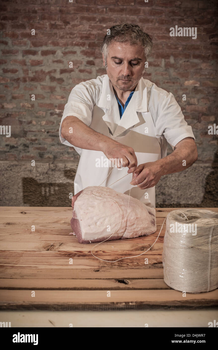 Butcher tying meat in shop Stock Photo - Alamy