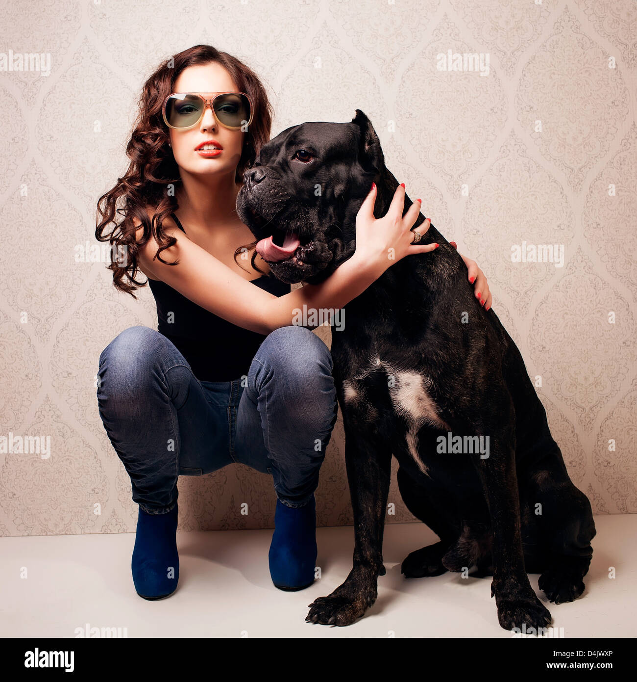 Pretty young woman smiling while embracing her cane corso Stock Photo ...