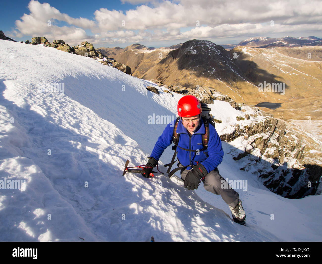 A climber topping out in Custs Gully on Great End, a grade one winter ...