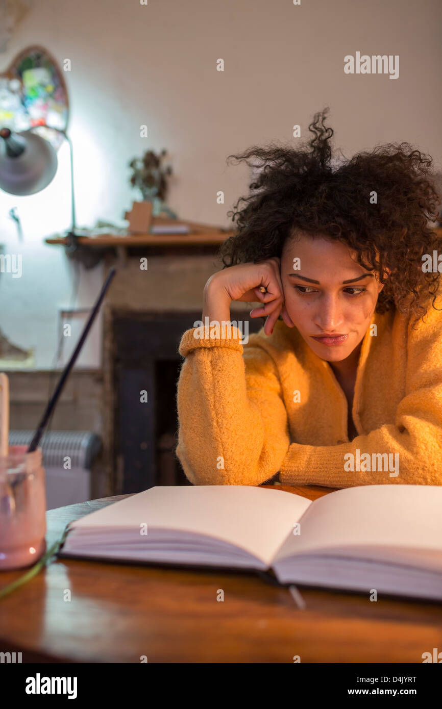 Woman reading book at desk Stock Photo - Alamy