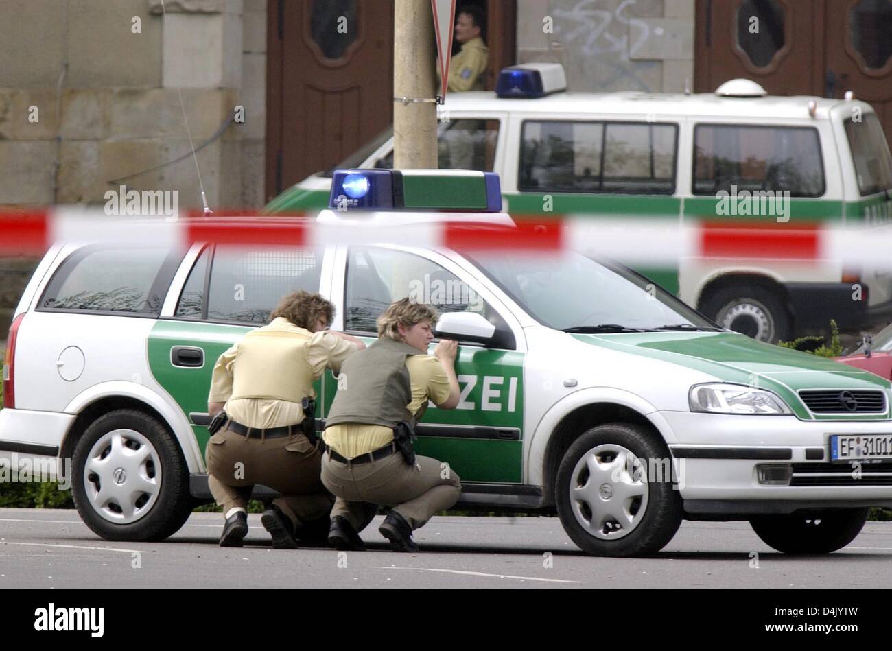 (dpa file) - Members of the police take cover behind a police car ...