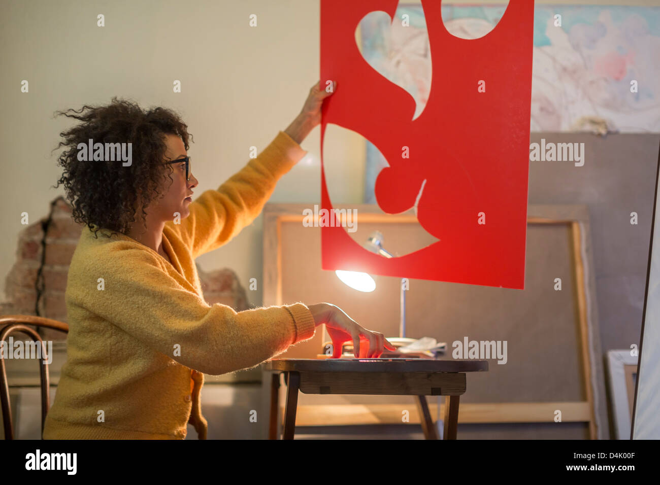 Artist cutting out red cardboard Stock Photo - Alamy
