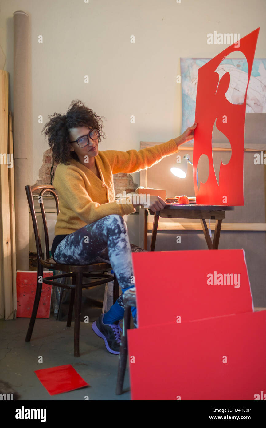 Artist cutting out red cardboard Stock Photo - Alamy