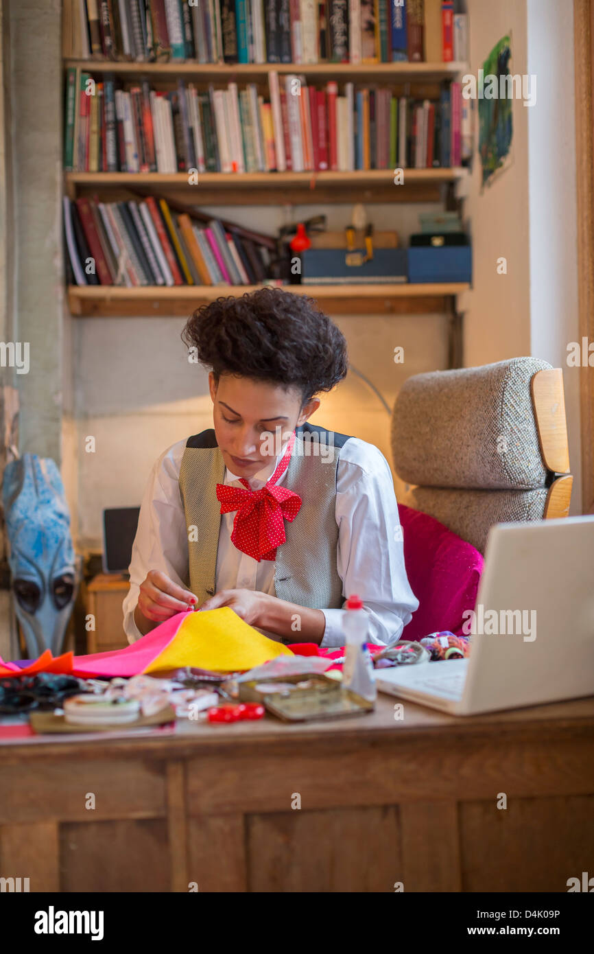 Designer sewing at desk in office Stock Photo - Alamy