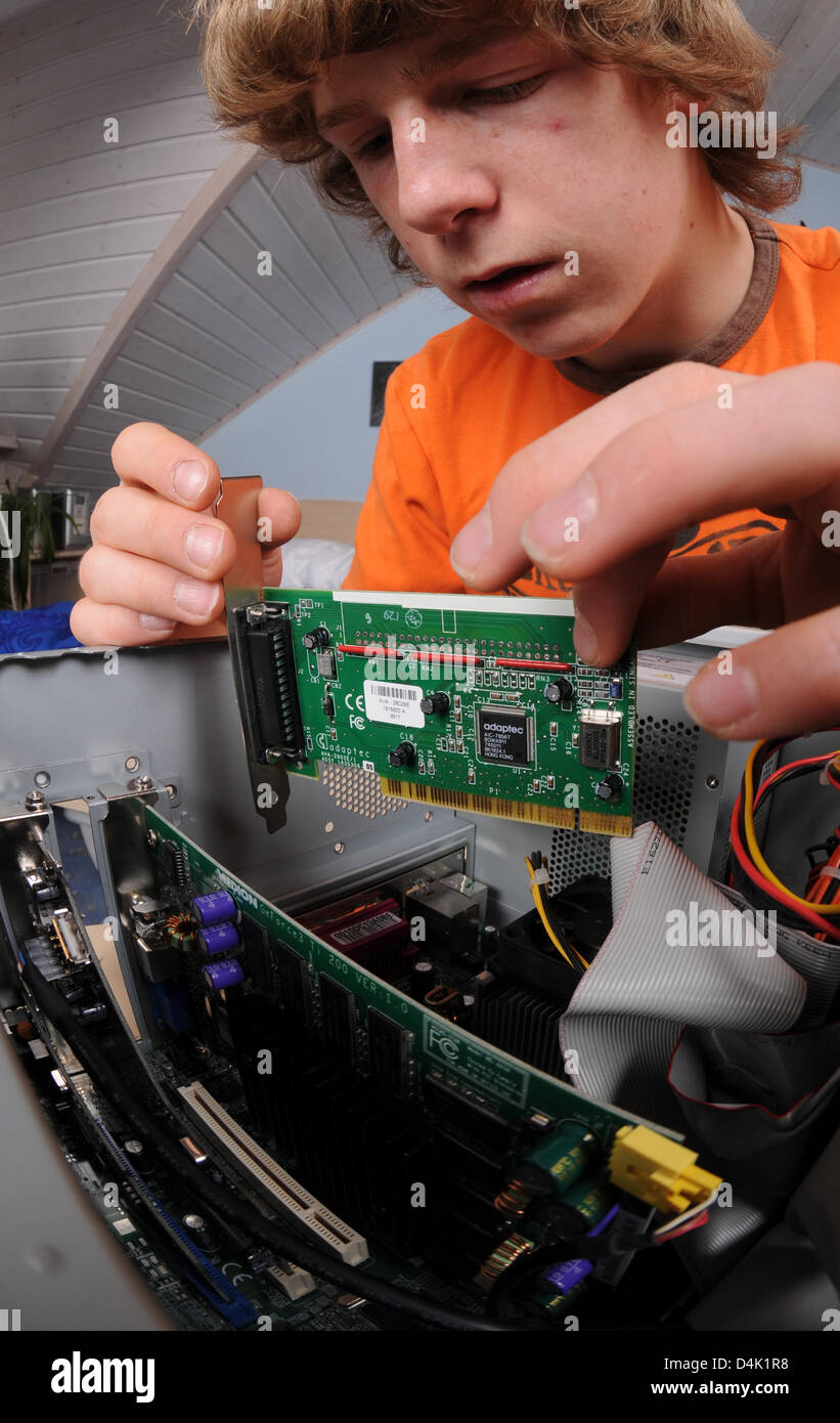 15-year-old Patrick stands behind the opened case of hs computer and ...