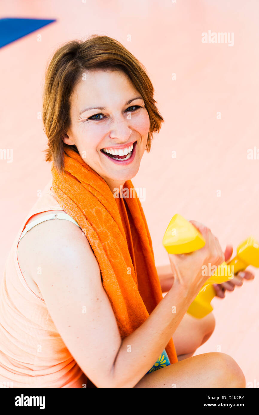 Smiling woman lifting weights outdoors Stock Photo - Alamy