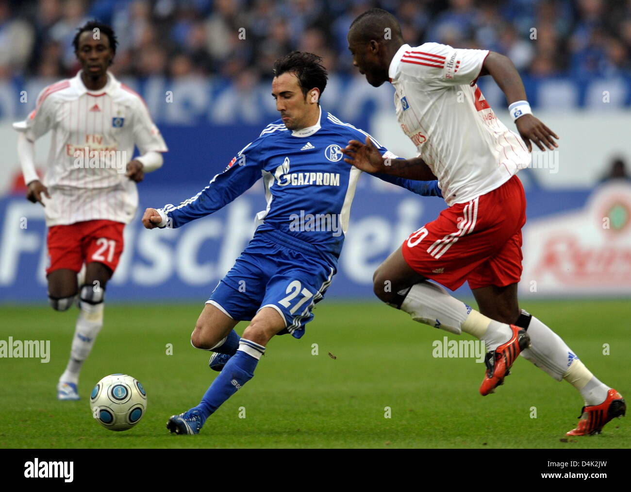 Schalke?s Vicente Sanchez (C) and Hamburg?s Guy Demel (R) and Jonathan Pitroipa (L) vie for the ...