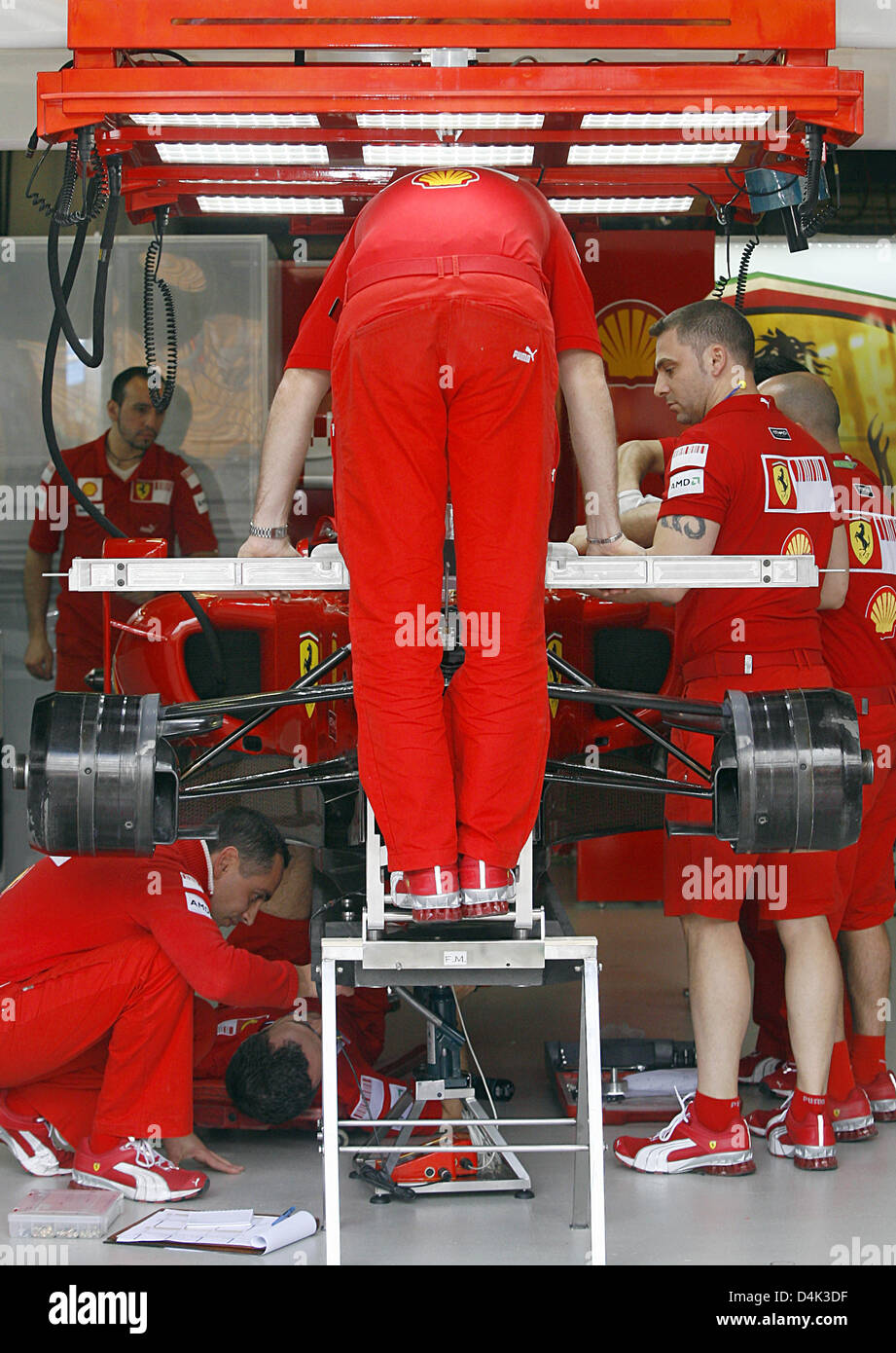 Mechanics of Ferrari work at a car inside the team garage at Albert ...