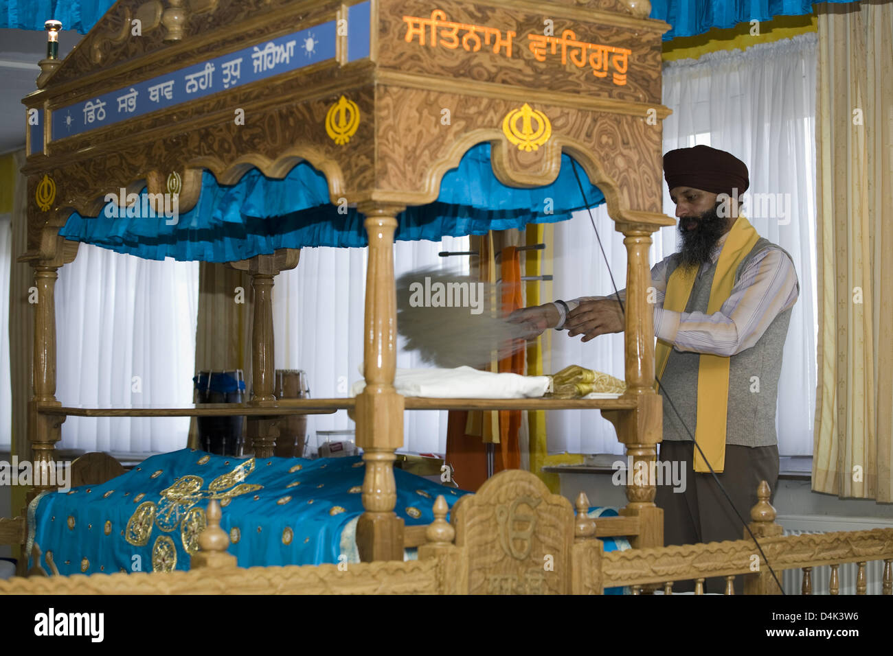 A Sikh brushes over the Granth, the sacred scripture of Sikhism, in ...