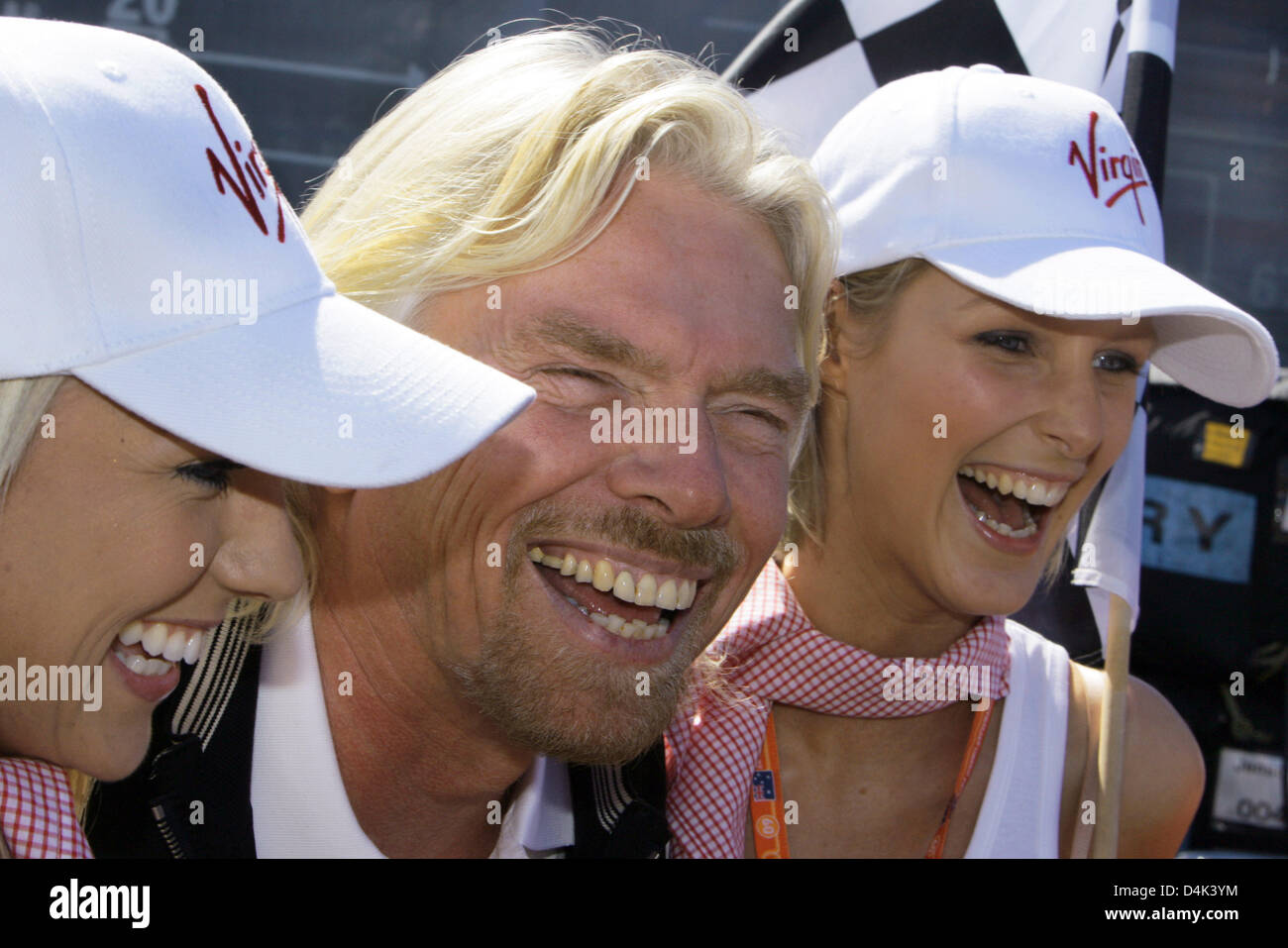 Virgin owner Sir Richard Branson (C) laughs together with two models ...