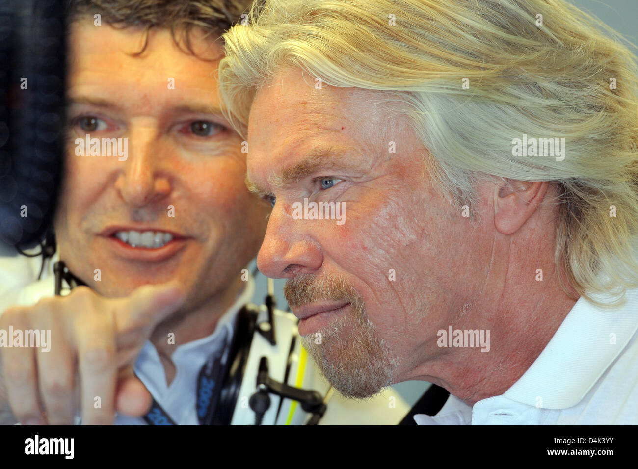 Virgin owner Sir Richard Branson (R) listens to Brawn GP?s CEO Nick Fry ...