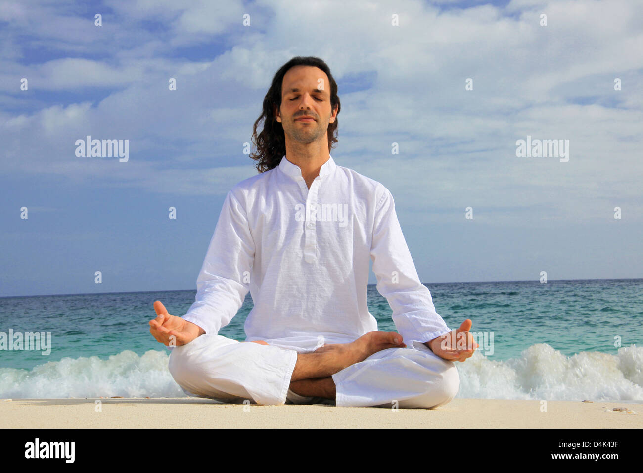 Man meditating on tropical beach Stock Photo - Alamy