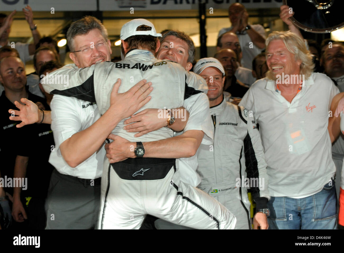 British Formula One driver Jenson Button of Brawn GP is embraced by ...