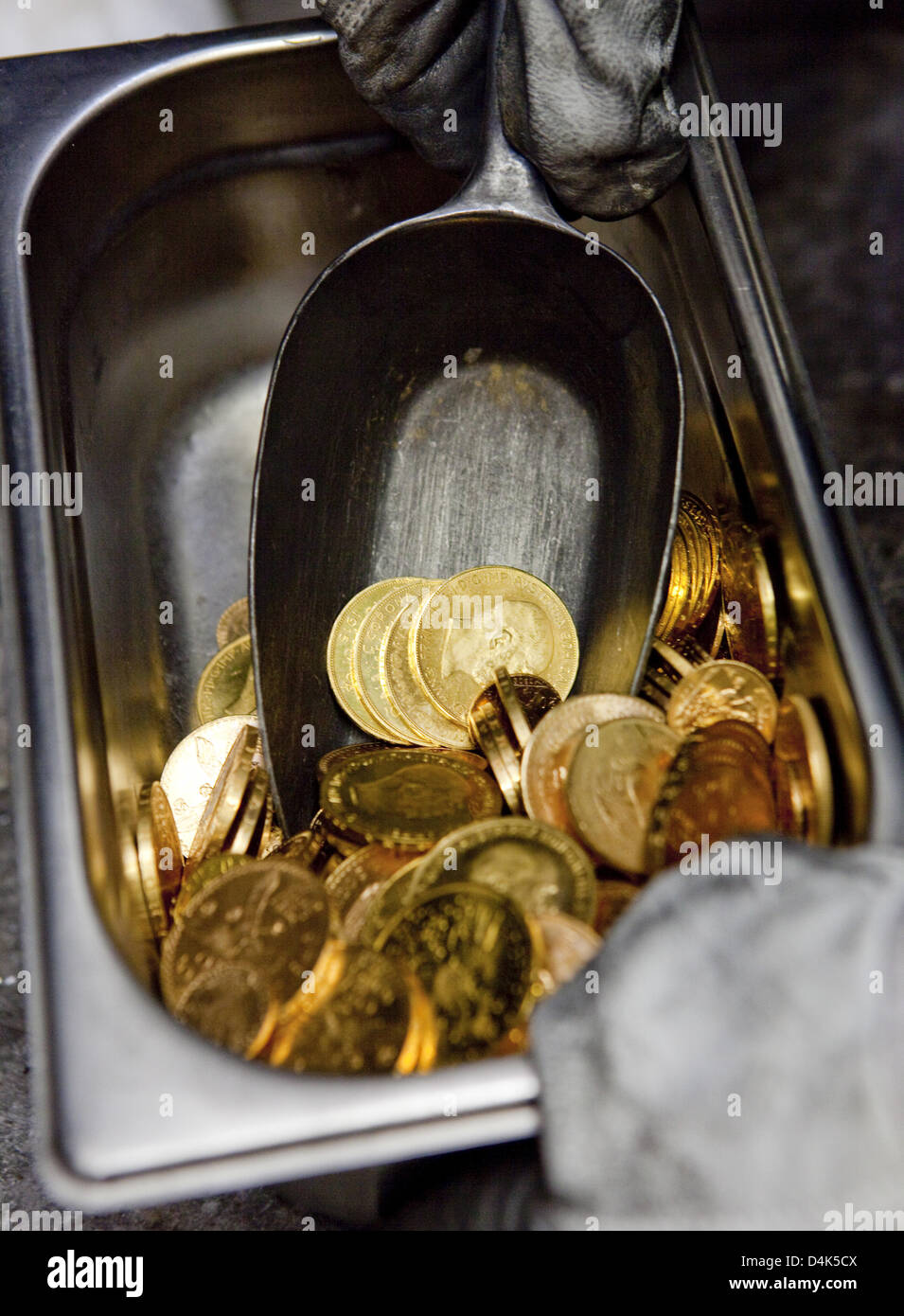 A member of staff fills old gold coins in a melting pot at the Heraeus ...
