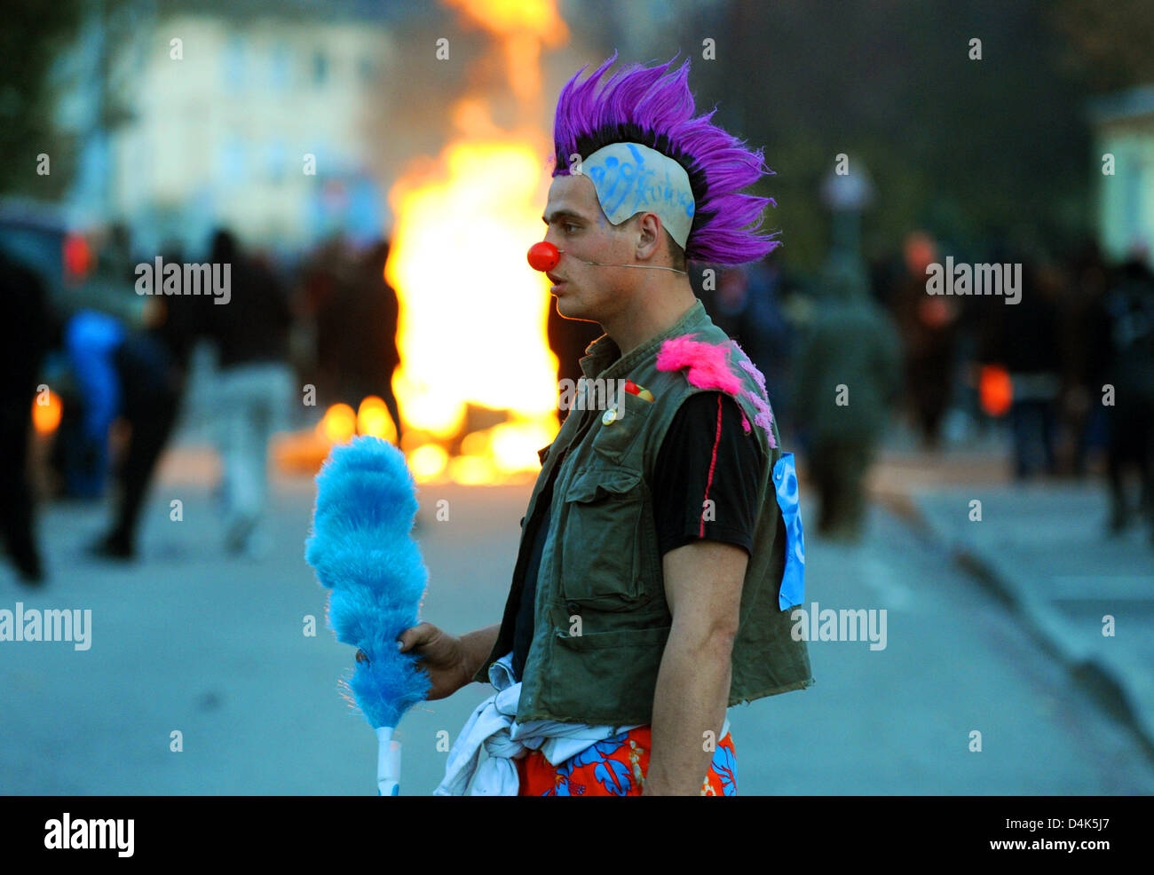 A dressed up anti-NATO activist stands at a street blockade in ...