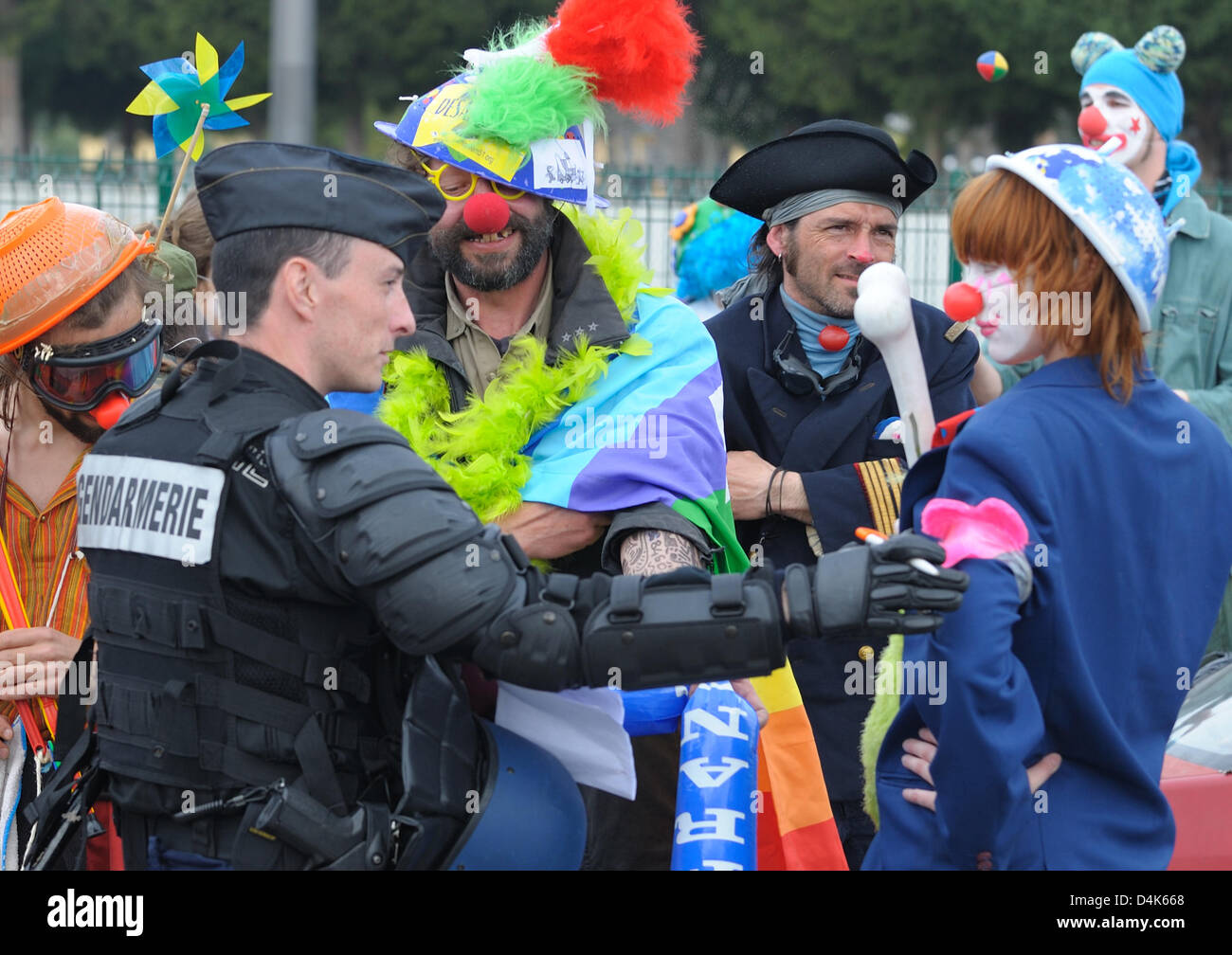 Protestors dressed as clowns talk with a policeman during a protest in ...