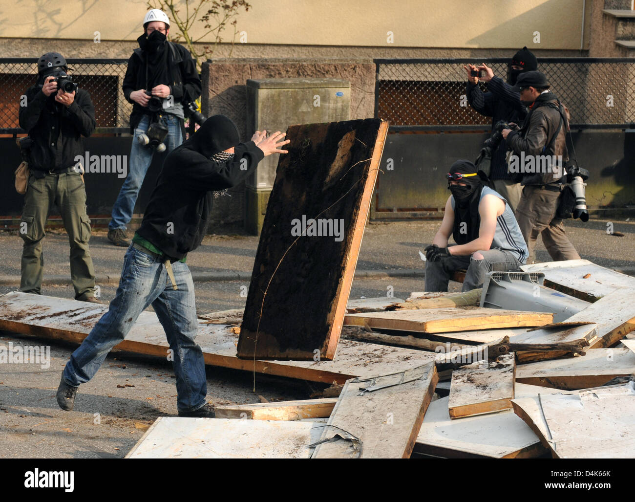 Hooded protestors against the NATO summit errect barricades at their ...