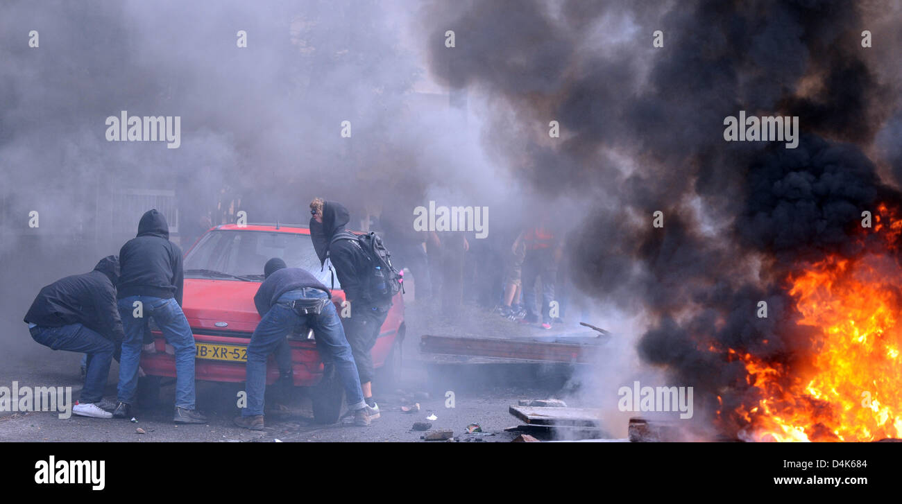 Hooded protestors turn their ?attention? to a car during riots on a ...