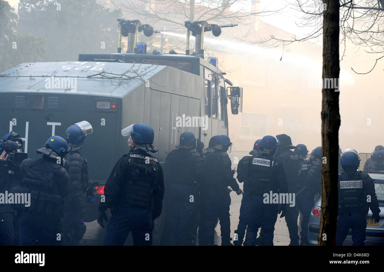 Riot police uses tear gas and a water cannon during riots on a street ...