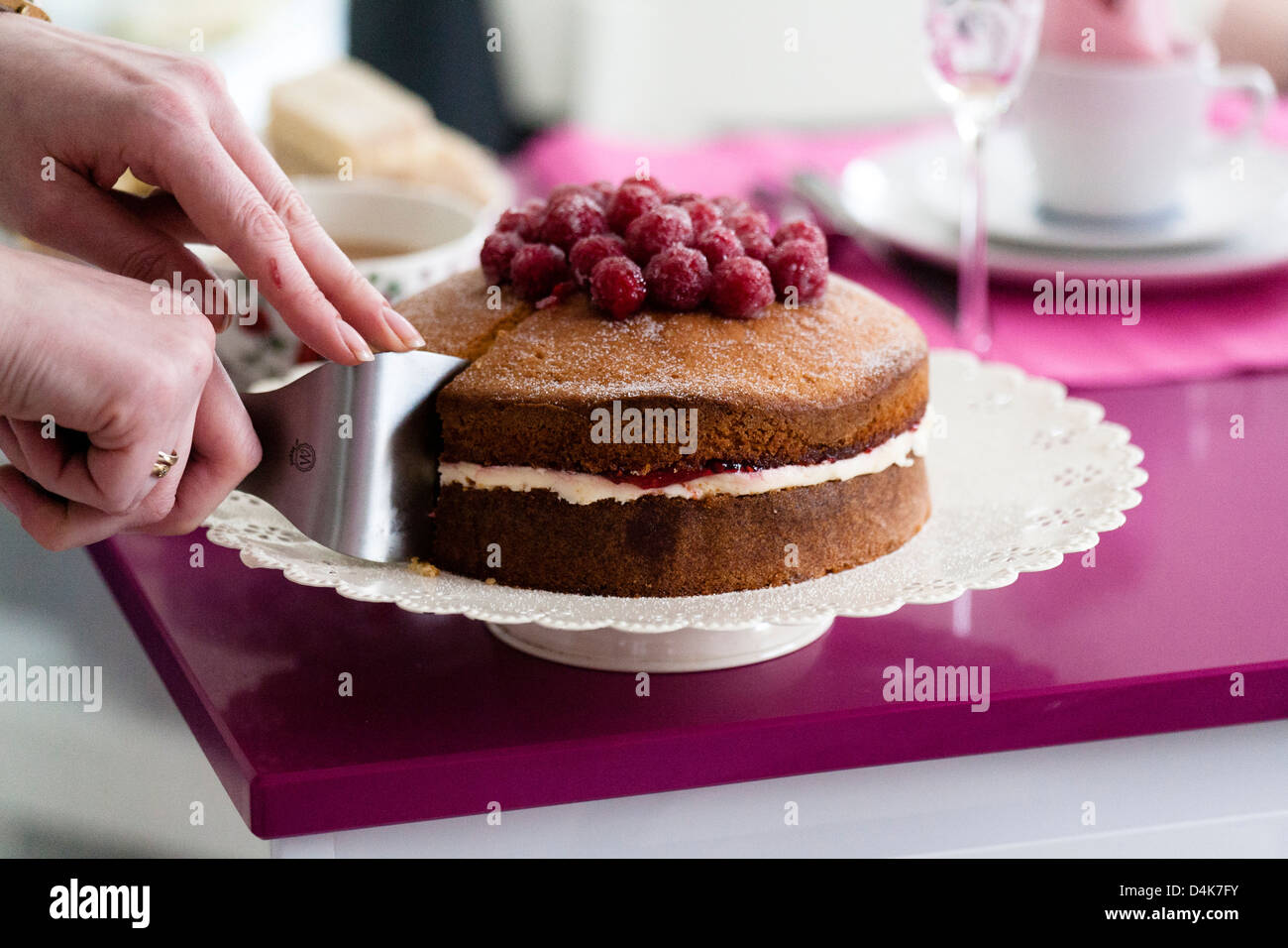 A sponge cake being sliced Stock Photo - Alamy