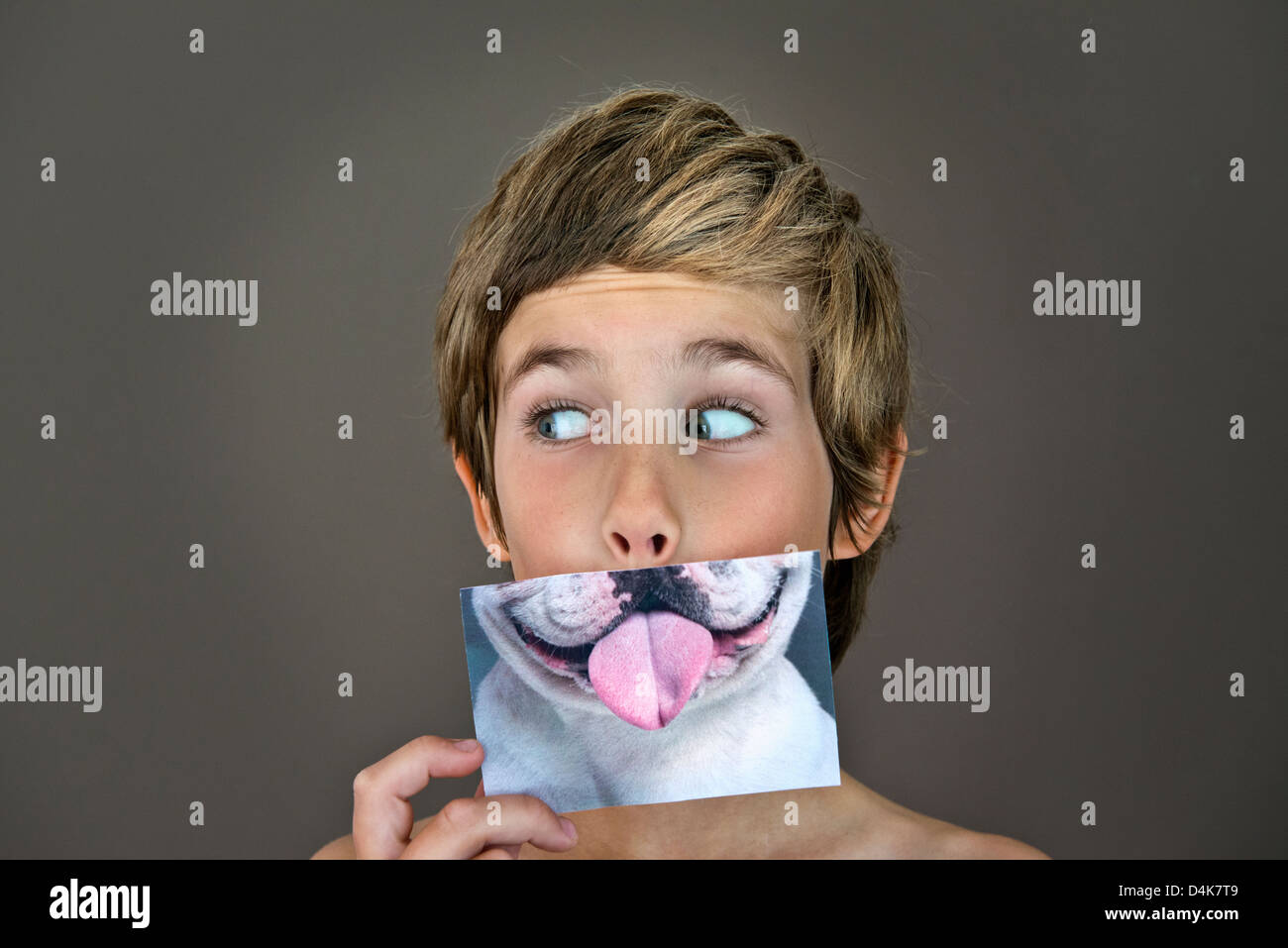Boy holding picture of dog over face Stock Photo - Alamy