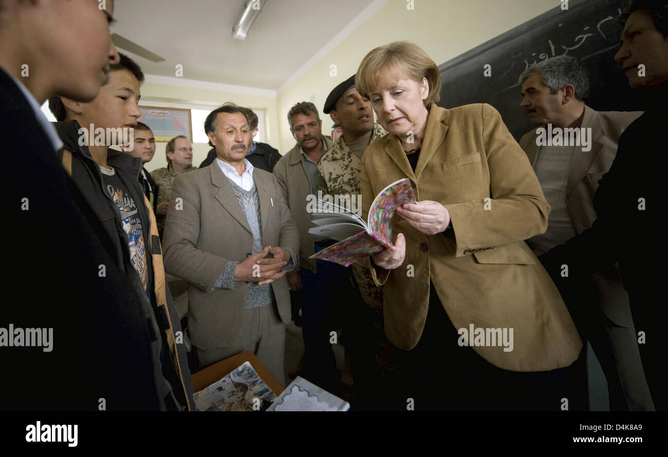 German Chancellor Angela Merkel (2-R) speaks with pupils of Ali Chapan ...