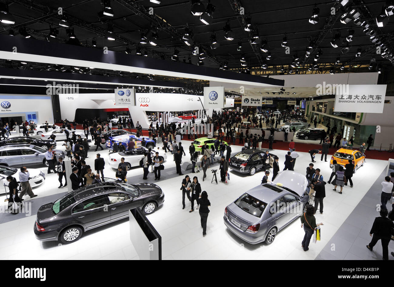 Visitors examine the cars on the press day of the Shanghai Auto Show ...
