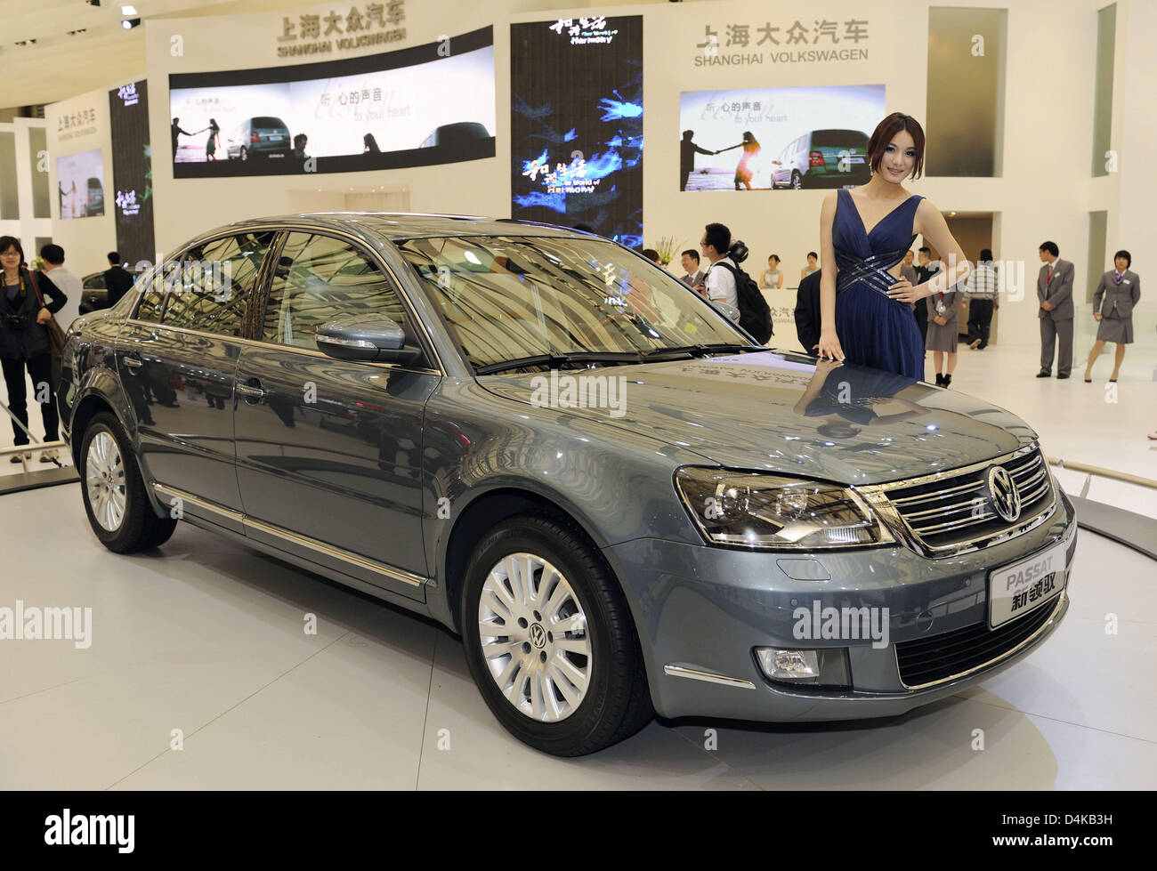 A model stands next to a VW Passat during the press day of the Shanghai ...