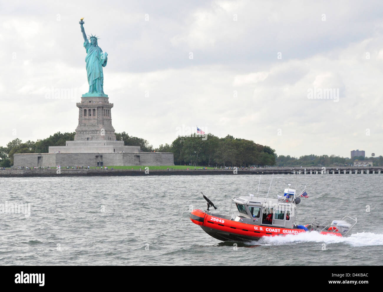 A U.S. Coast Guard vessel from Station New York passes by the Statue of ...