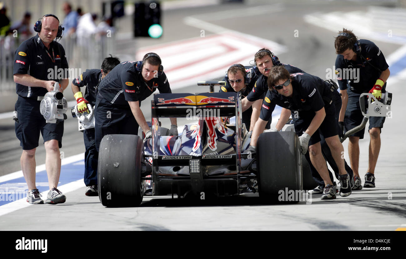 Mechanics of Red Bull Racing push German Formula One driver Sebastian ...