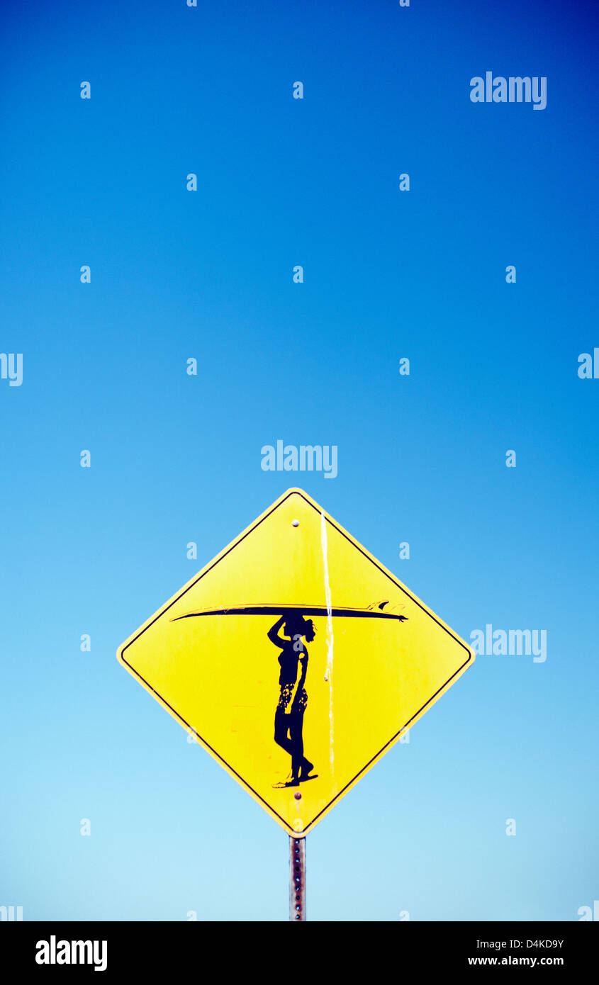 Woman carrying surfboard on sign Stock Photo - Alamy