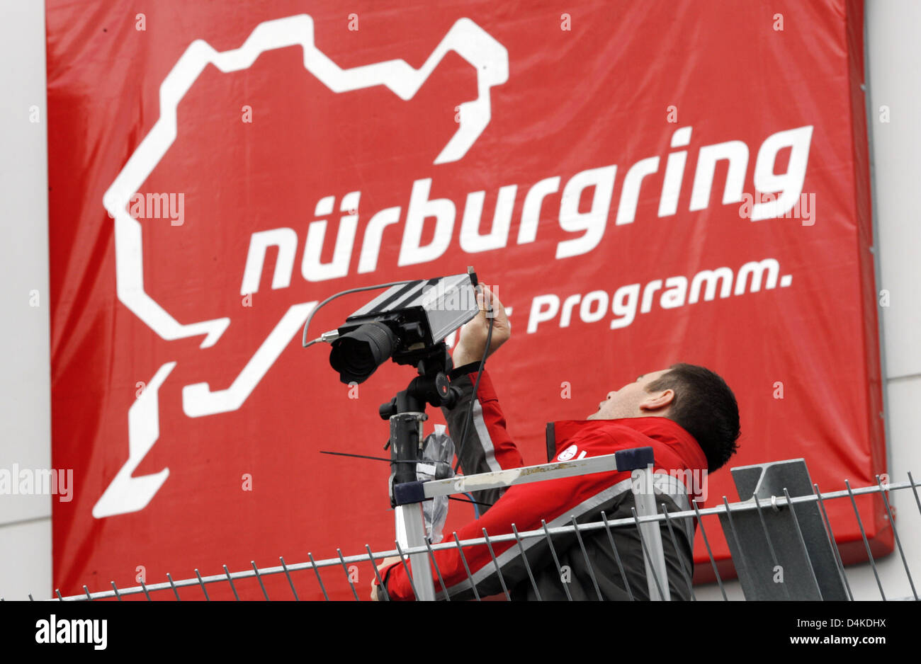 A technician prepares a camera in front of a banner of Nuerburgring ...