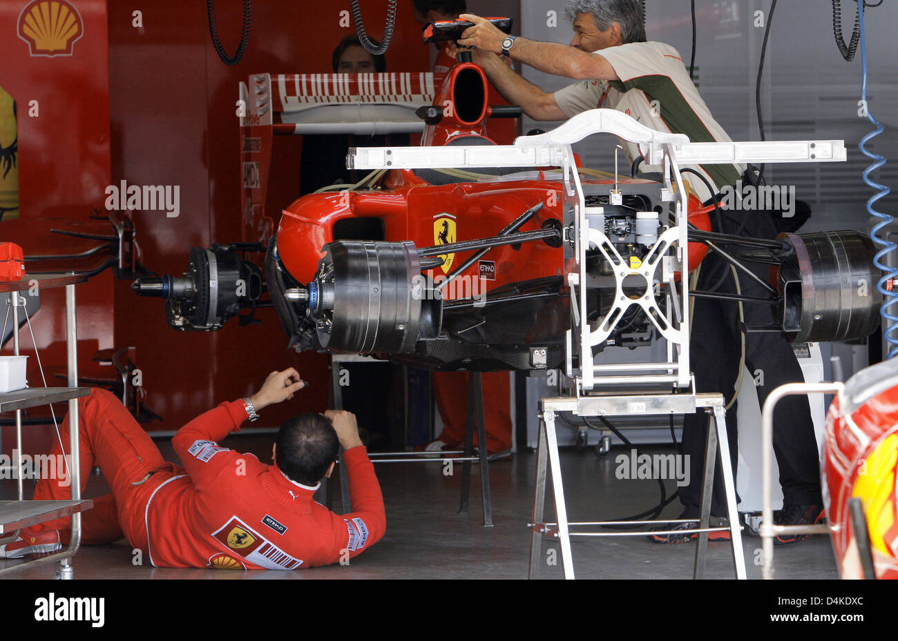 Mechanics of Scuderia Ferrari work on the racing car of Brazil?s Felipe ...