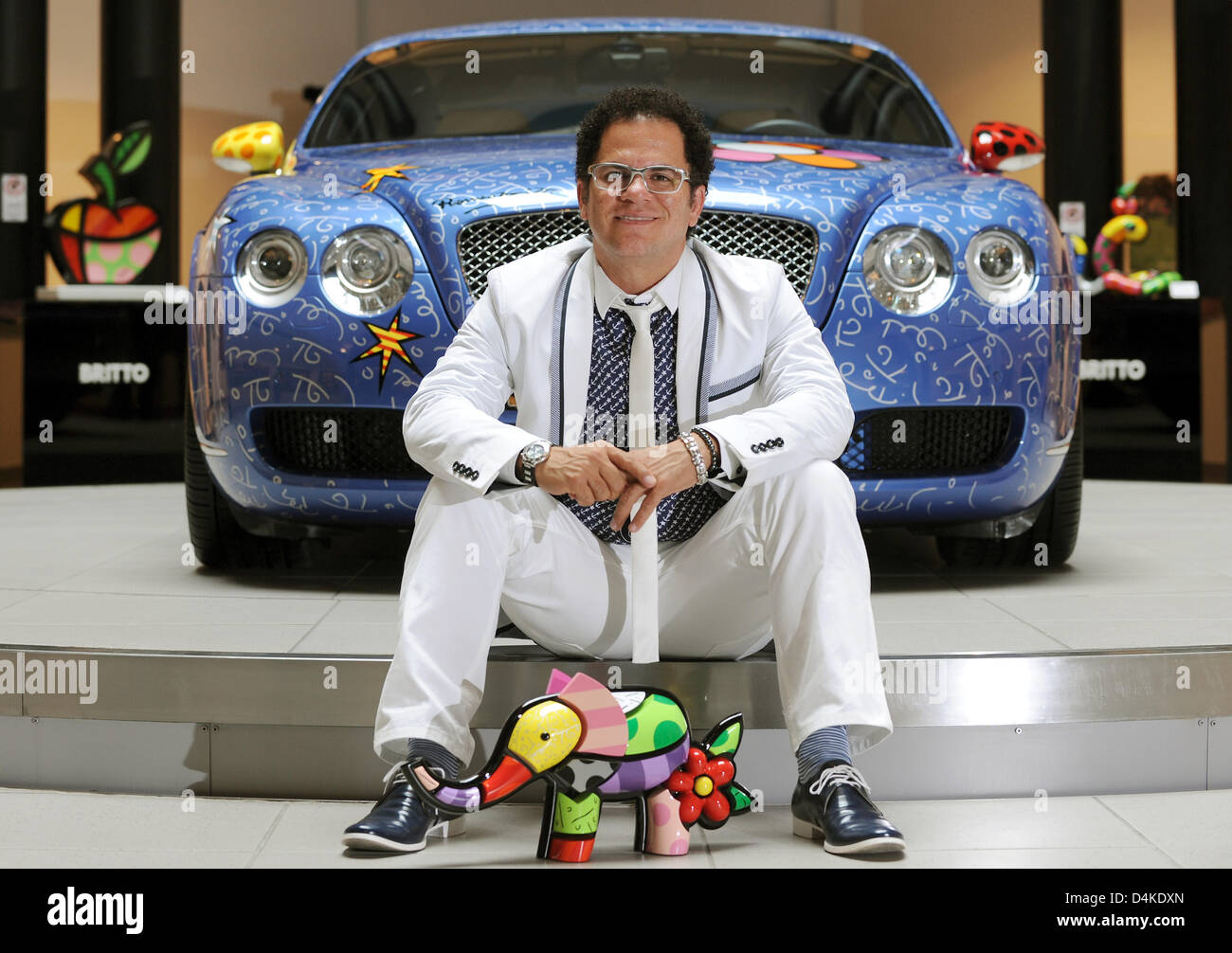Brazilian artist Romero Britto sits in front of a Bentley Continental ...