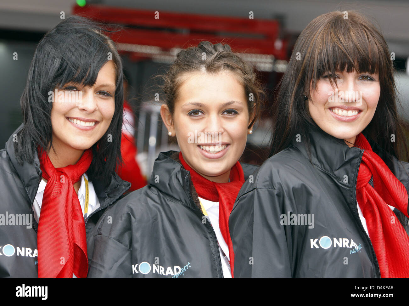 Hostesses smile in the pit lane during the third training session at ...