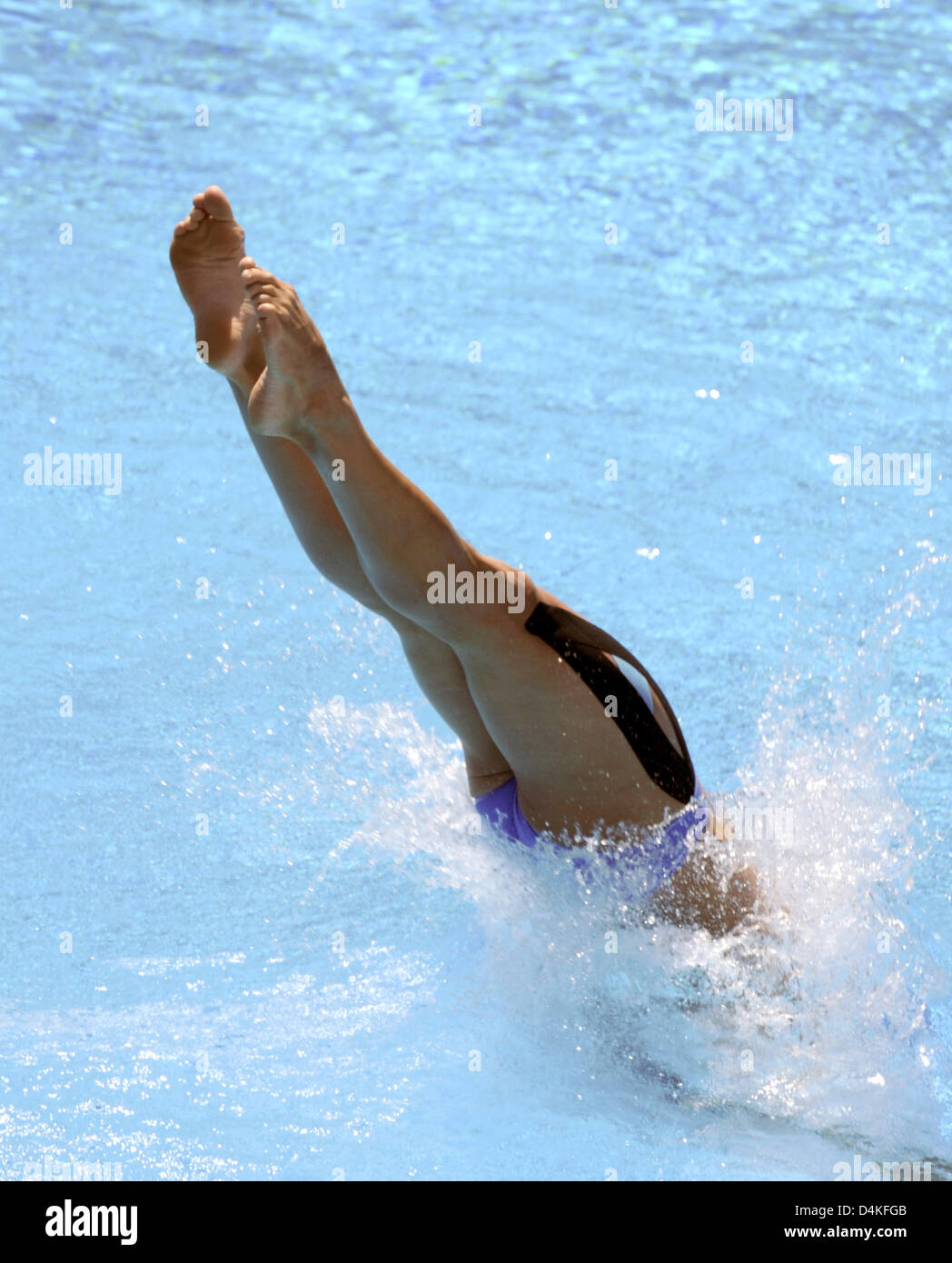 A participant jumps off the 1m diving board during the qualification ...