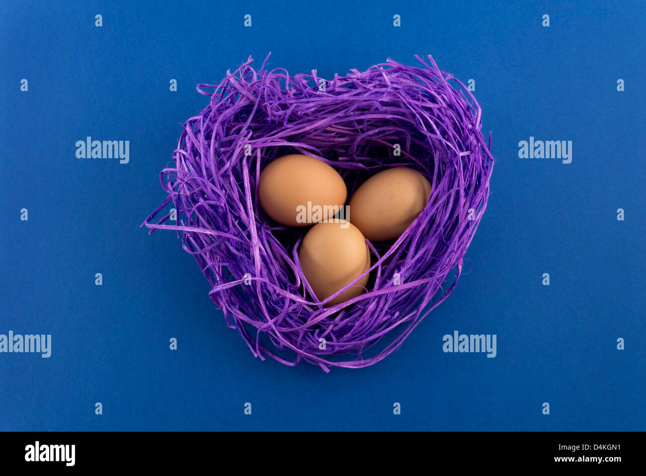 Heart shaped violet nest with eggs on blue background Stock Photo - Alamy