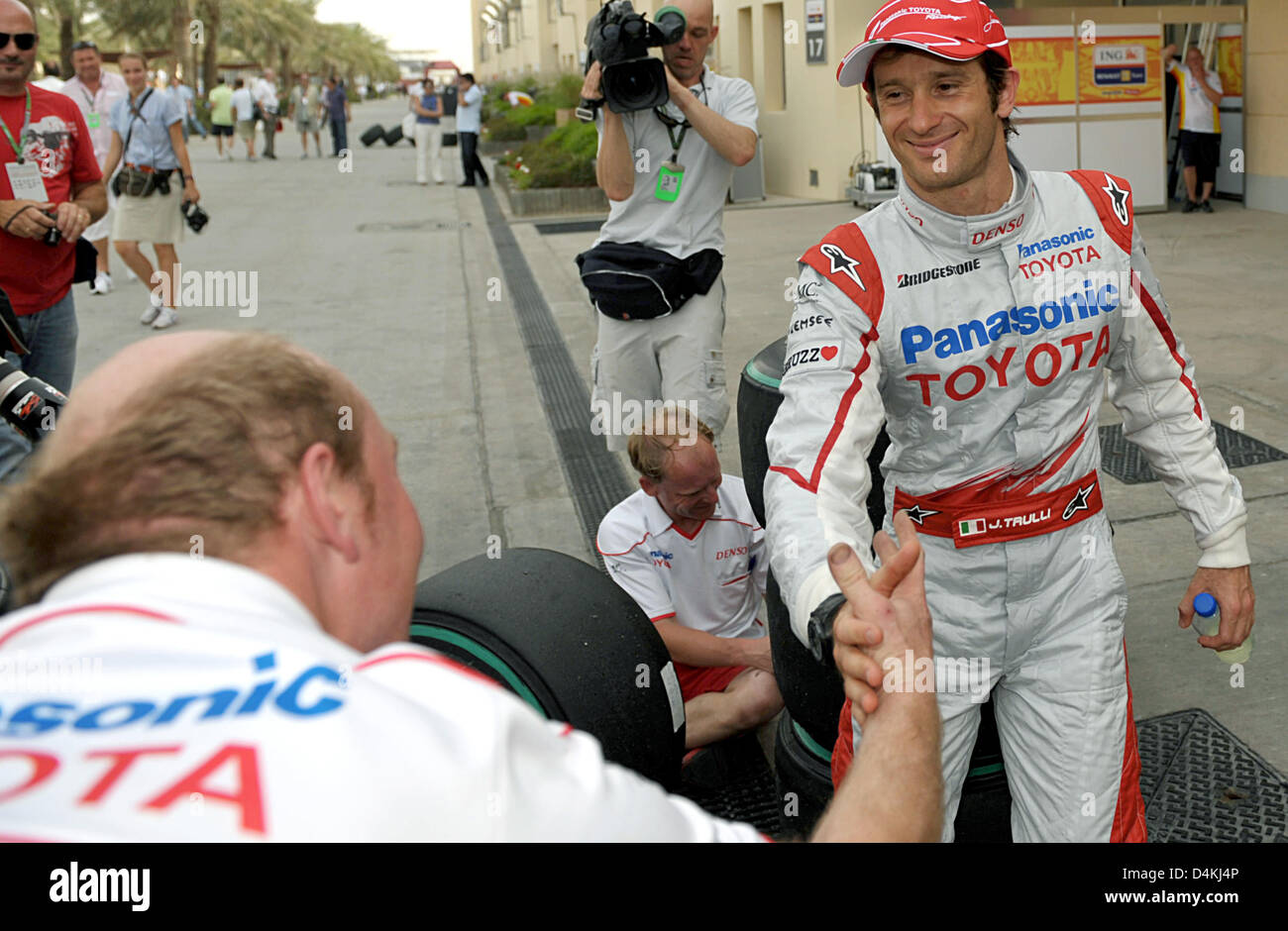 Italian Formula One driver Jarno Trulli of Toyota (R) shakes hands with ...