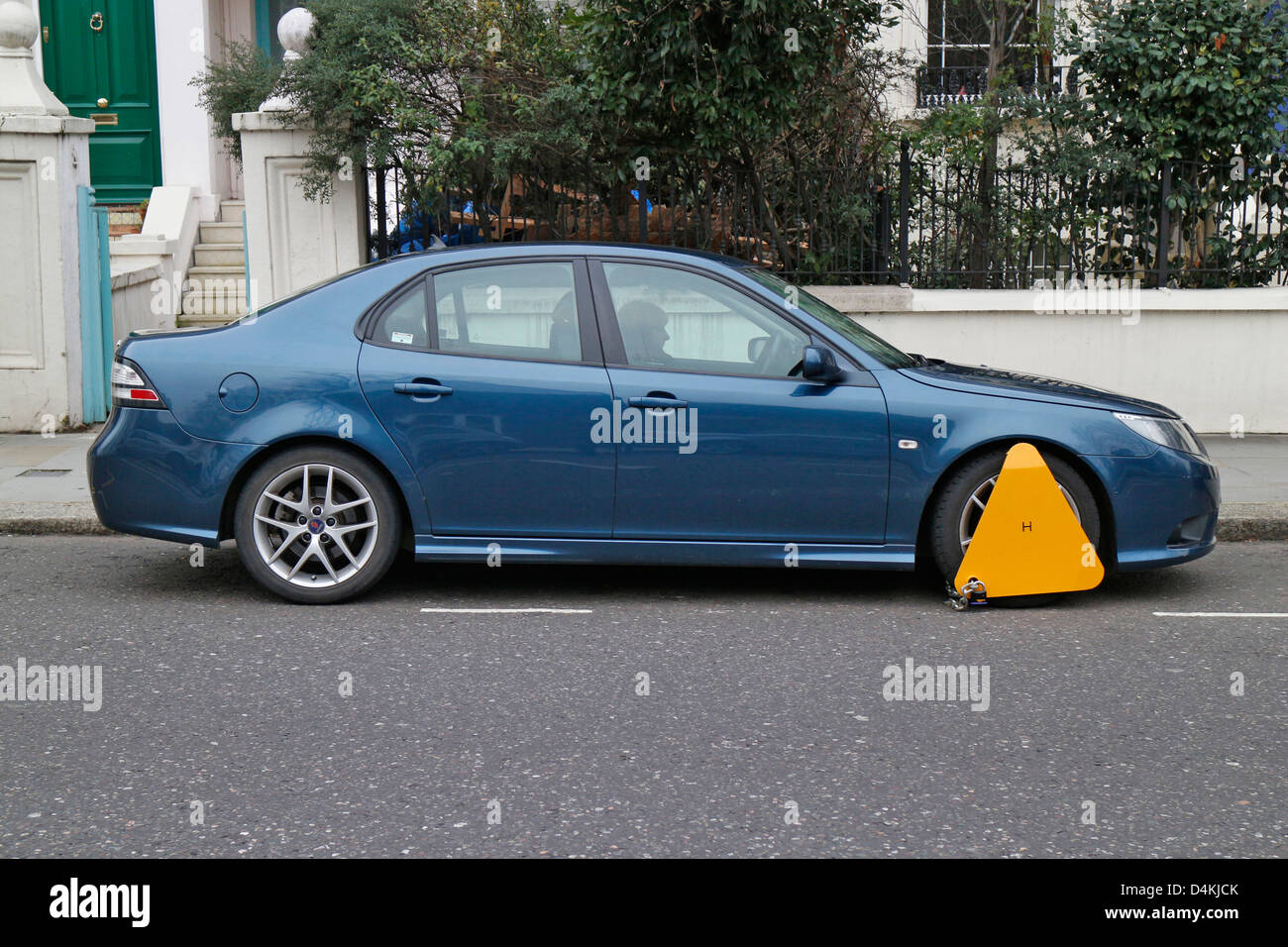 Yellow wheel clamp on car parked illegally in a London street. 130605 ...