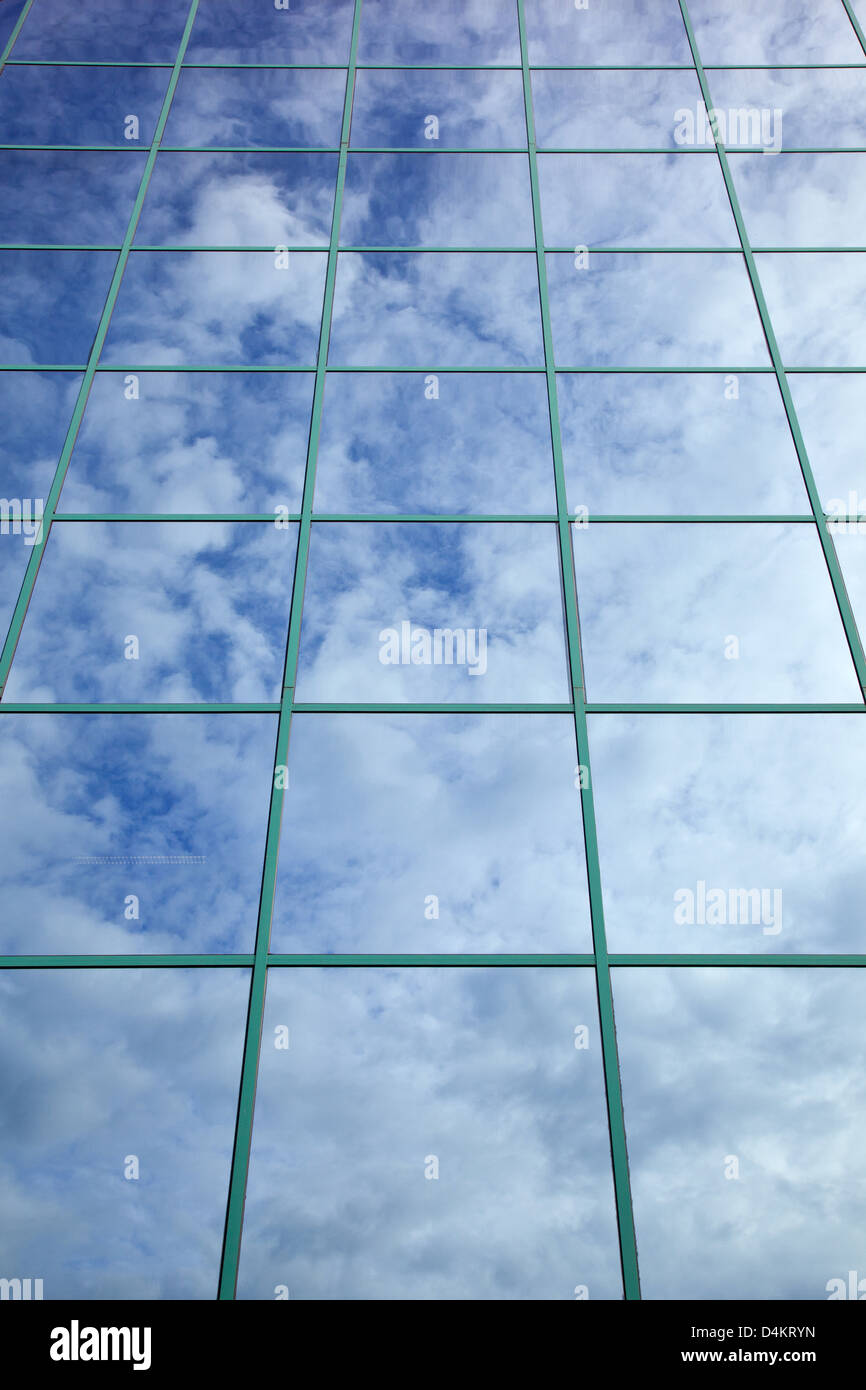 clouds and blue sky reflected in glass facade of office building Stock ...