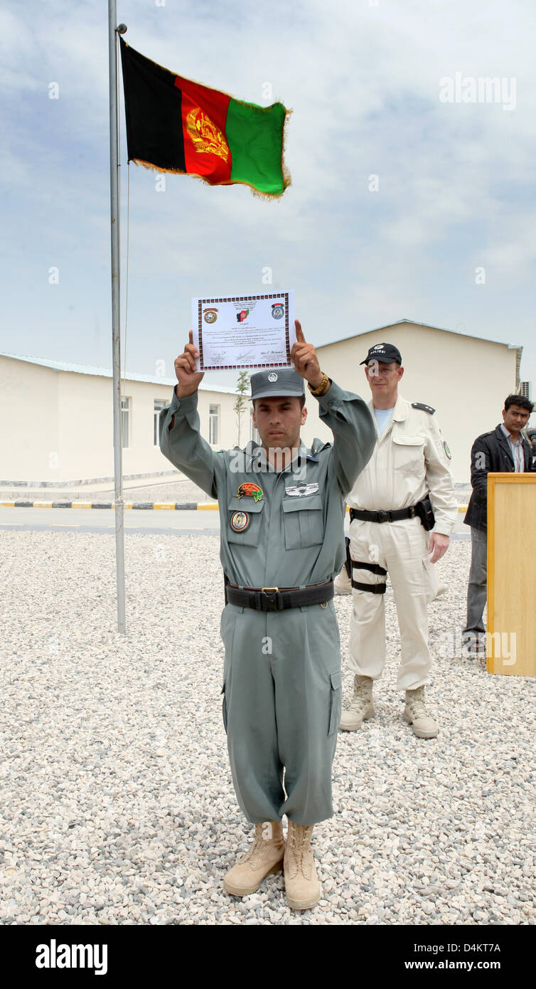 One of the 55 police officers holds up a certificate which he received ...