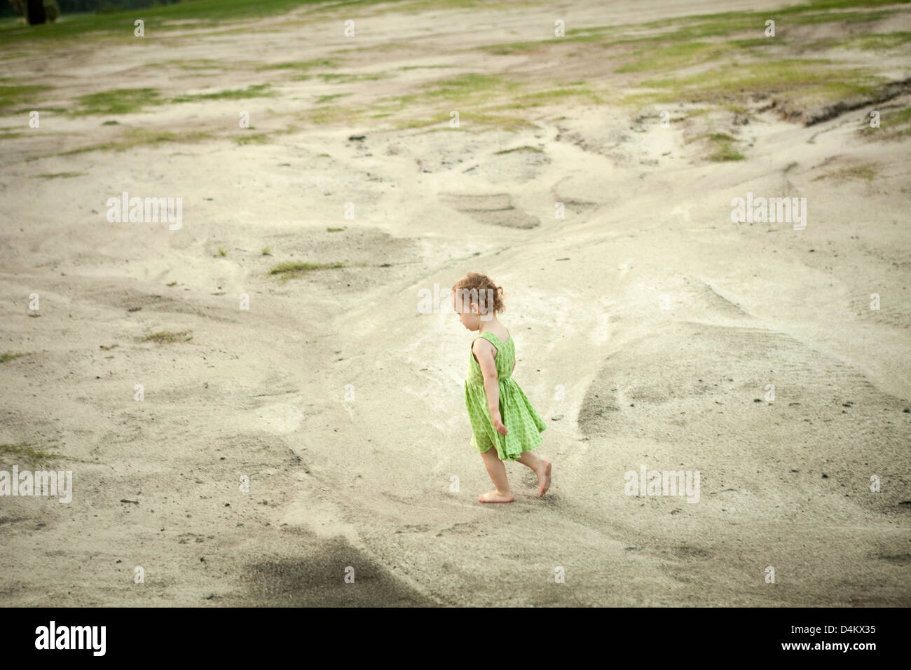 Toddler girl walking in sand Stock Photo - Alamy