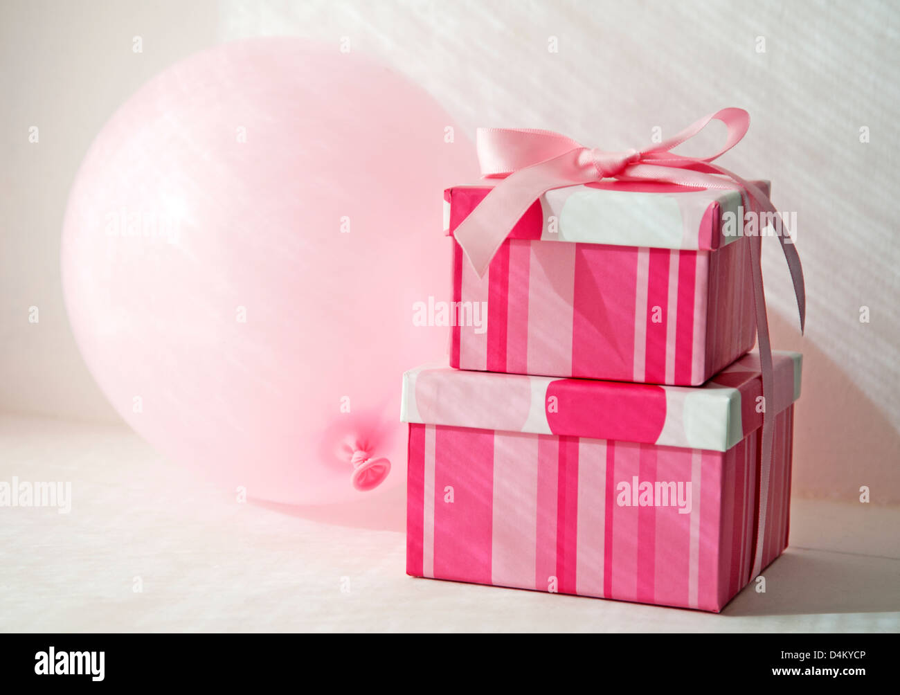 Pink gift boxes tied up with pink ribbon beside a pink balloon Stock ...