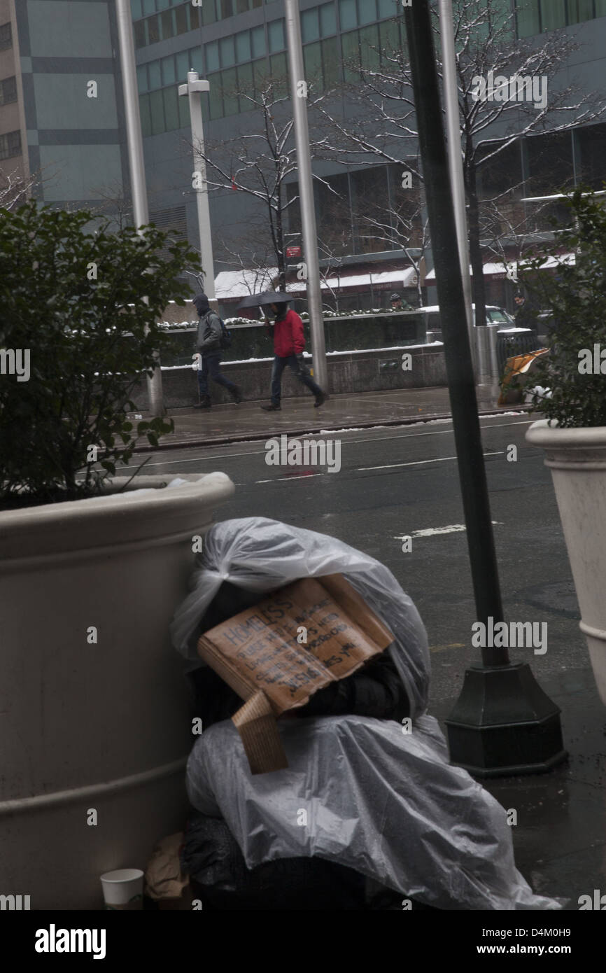 Homeless man wrapped in plastic simultaneously begging and fighting off ...