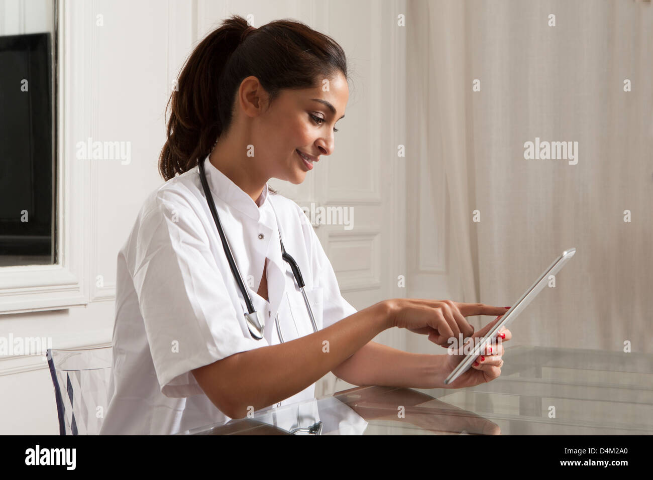 Doctor using tablet computer in office Stock Photo - Alamy