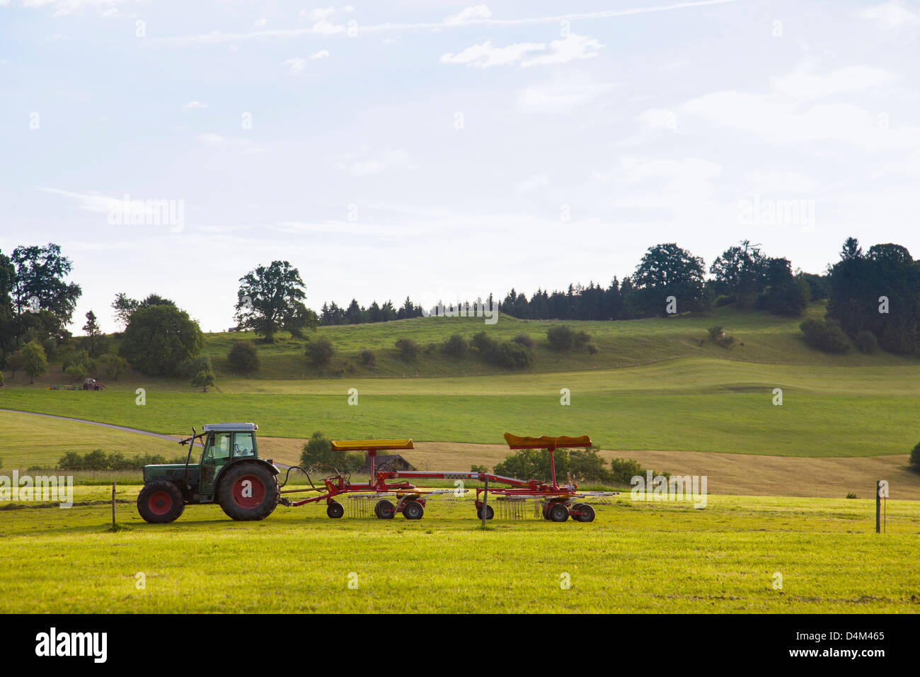 Tractor driving in rural field Stock Photo - Alamy