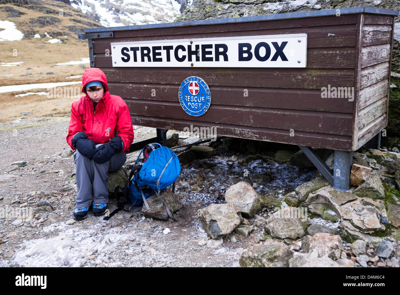 A hiker in shock waiting by a Stretcher box, Rescue Post in the Lake ...